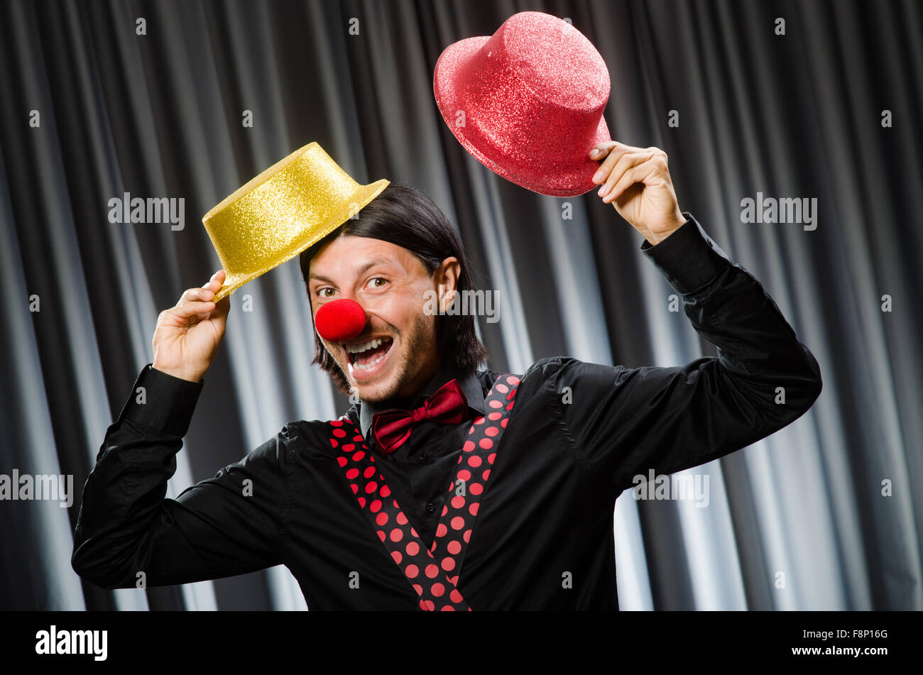 Funny clown in humorous concept against curtain Stock Photo - Alamy
