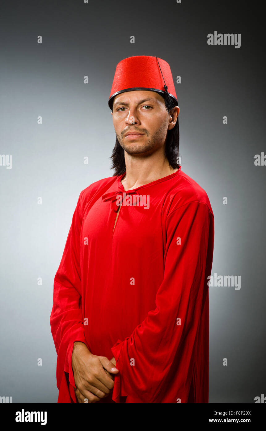 Funny man in red dress wearing fez hat Stock Photo - Alamy