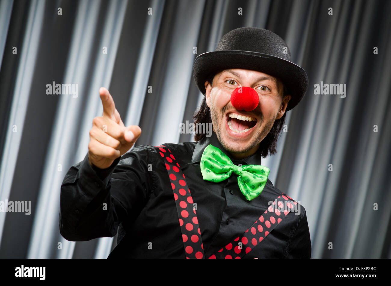 Funny clown in humorous concept against curtain Stock Photo - Alamy