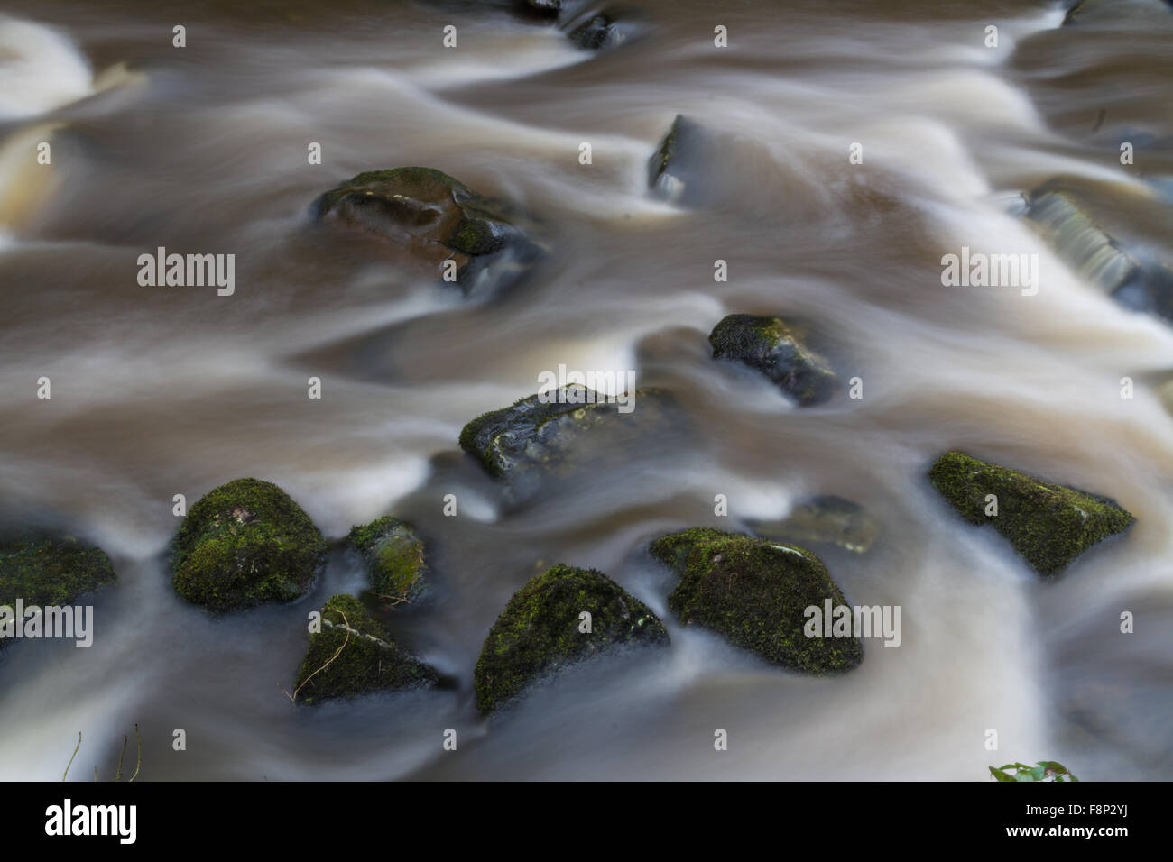 Detail of water cascading onto rocks at the bottom of a waterfall ...