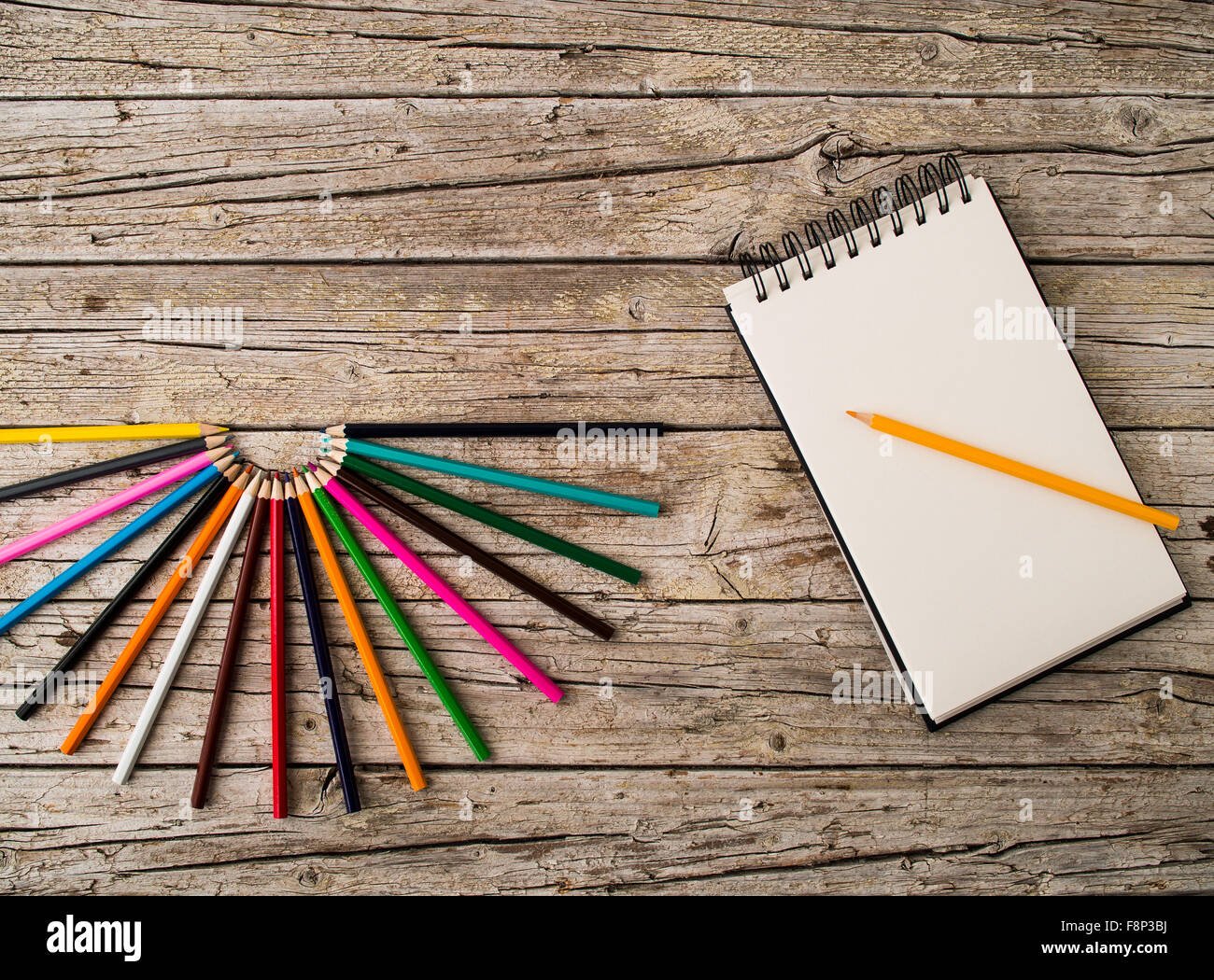 Colorful pencil crayons and notebook on wooden background Stock Photo ...