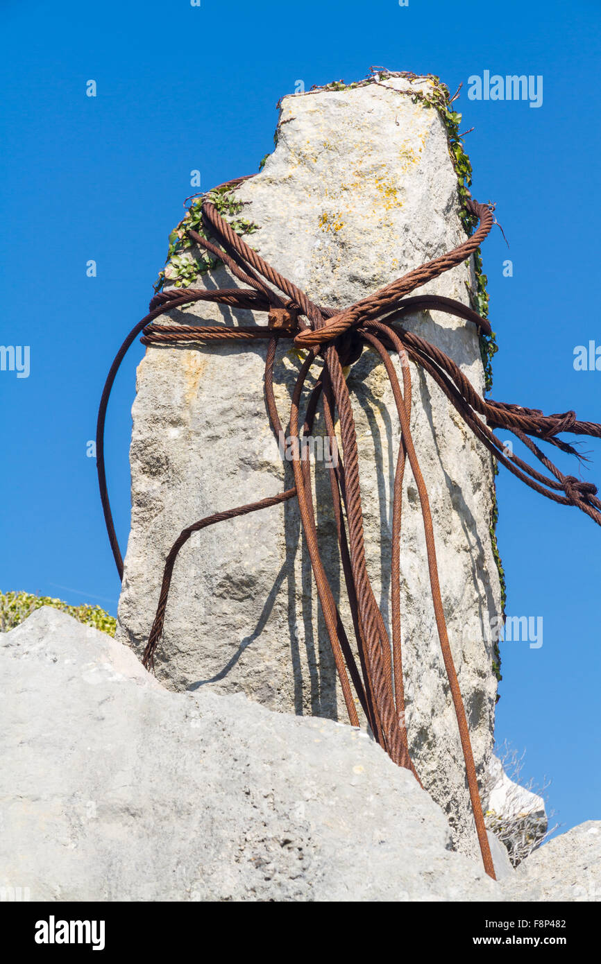 Old rusty iron cables looped around a limestone rock in a quarry Stock ...
