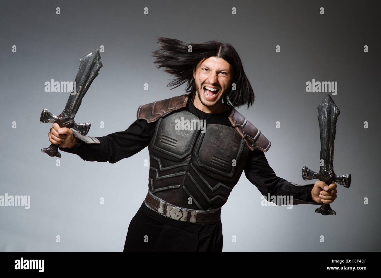 Angry knight with sword against dark background Stock Photo - Alamy