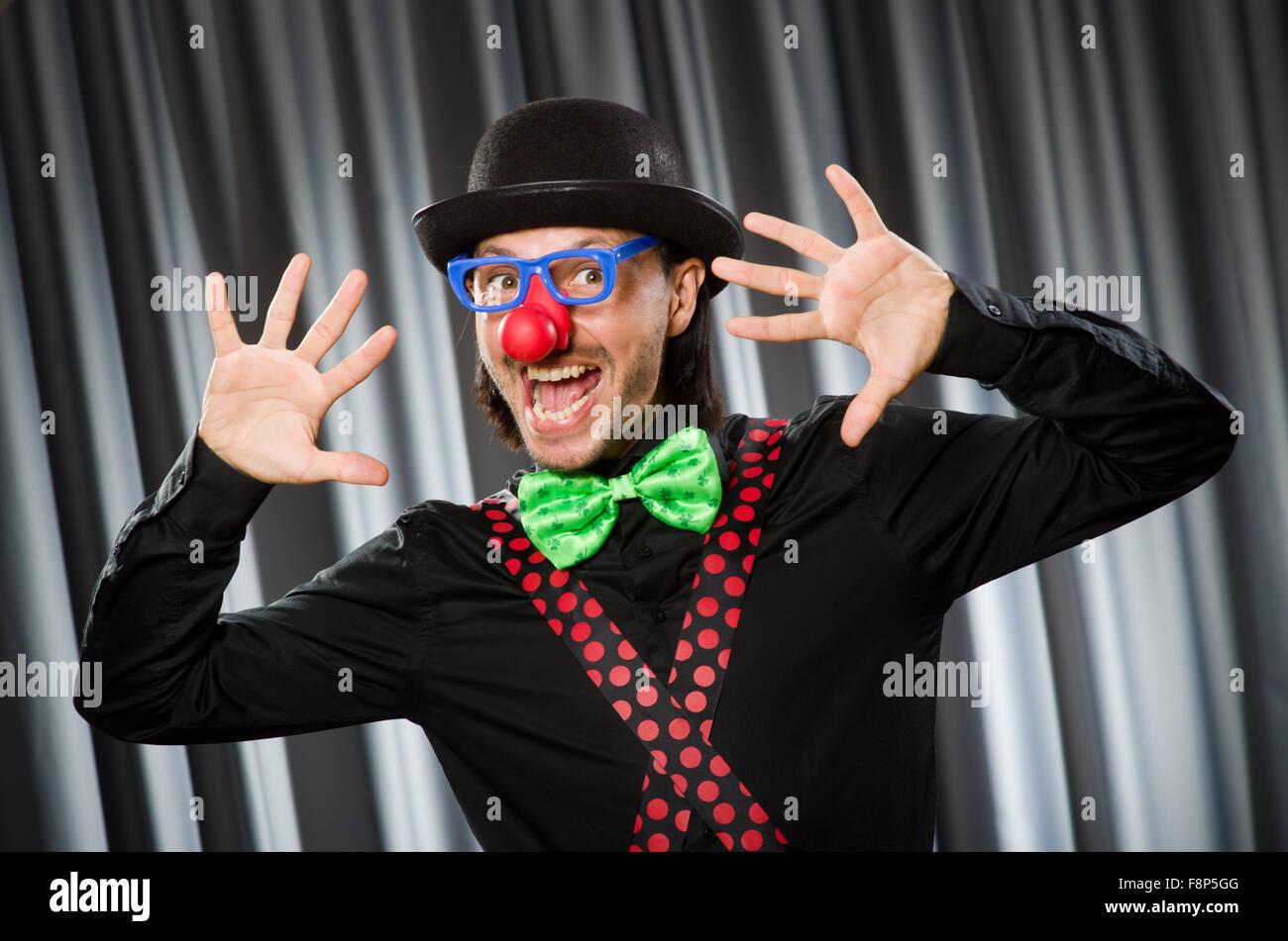 Funny clown in humorous concept against curtain Stock Photo - Alamy