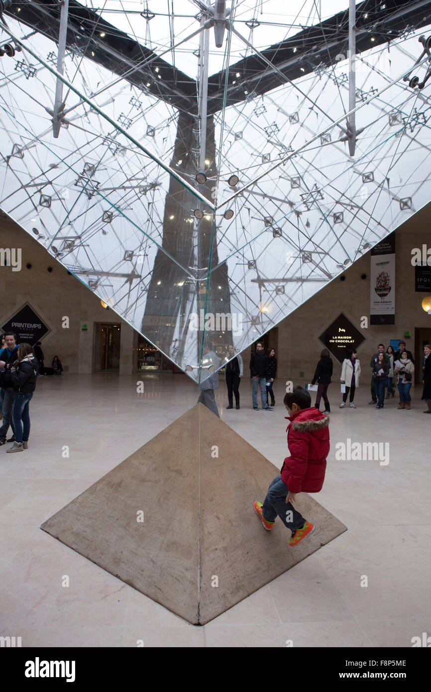 A young boy plays on a stone pyramid within the Louvre art gallery in ...
