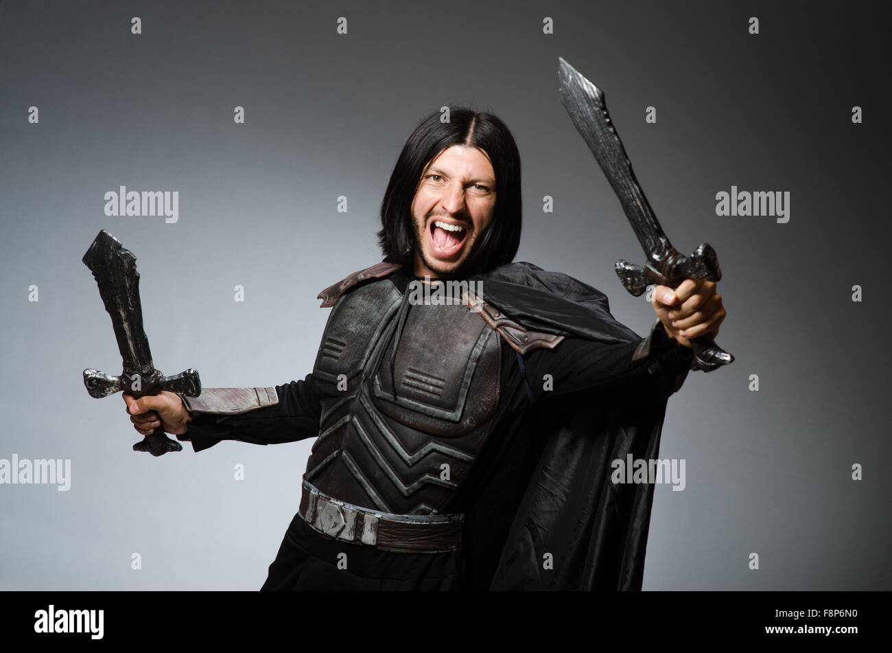 Angry knight with sword against dark background Stock Photo - Alamy