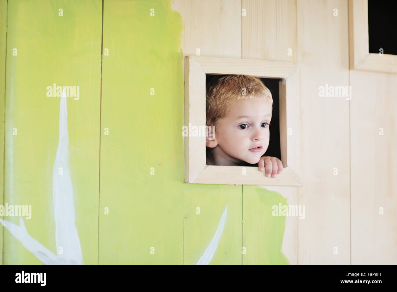 happy cute child in a wooden window at playground Stock Photo - Alamy