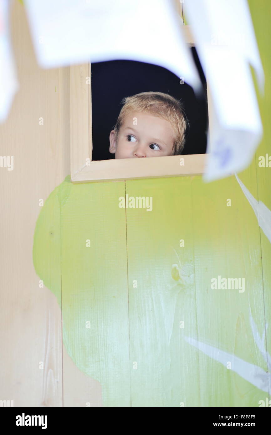 happy cute child in a wooden window at playground Stock Photo - Alamy