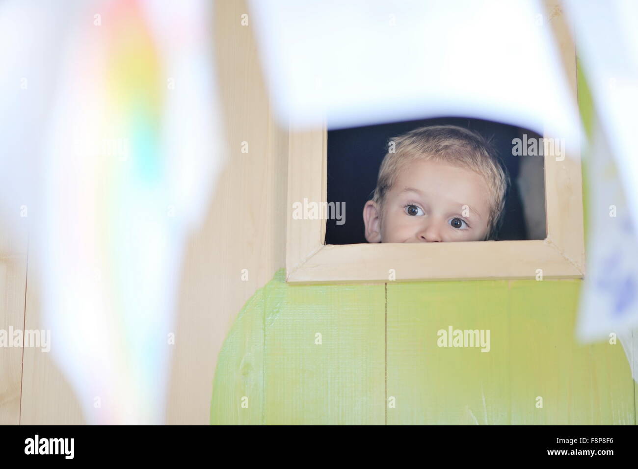 happy cute child in a wooden window at playground Stock Photo - Alamy