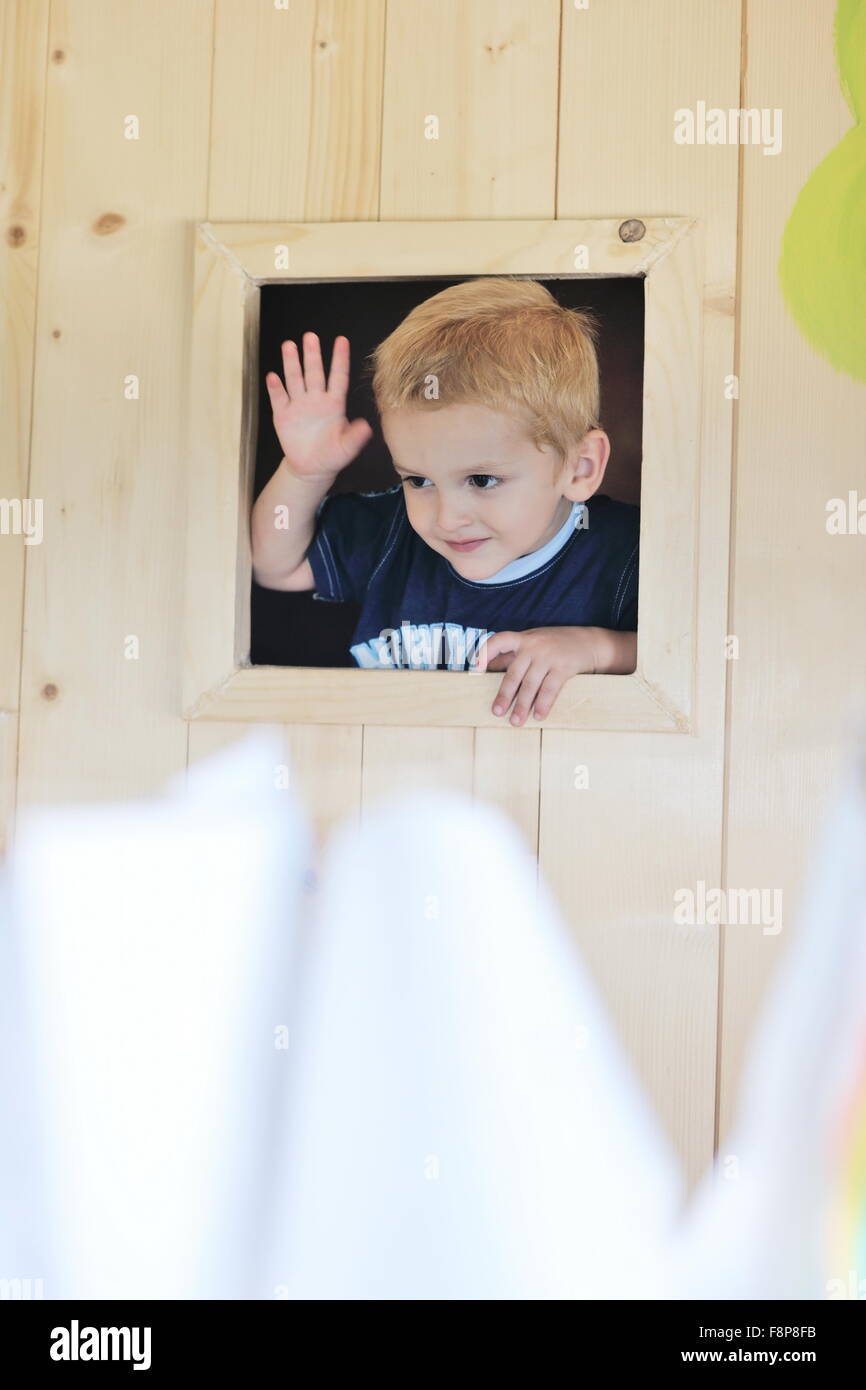 happy cute child in a wooden window at playground Stock Photo - Alamy