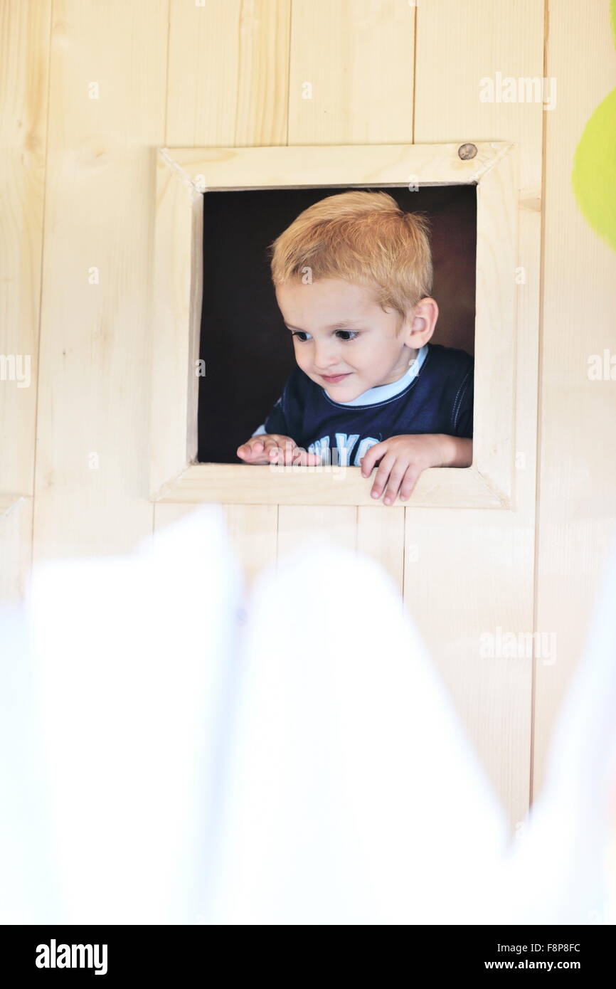 happy cute child in a wooden window at playground Stock Photo - Alamy