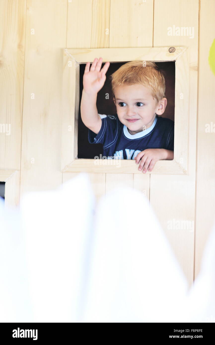 happy cute child in a wooden window at playground Stock Photo - Alamy