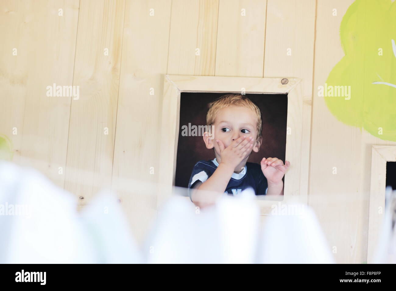 happy cute child in a wooden window at playground Stock Photo - Alamy