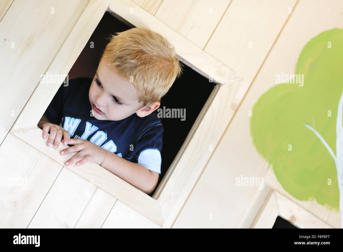 happy cute child in a wooden window at playground Stock Photo - Alamy