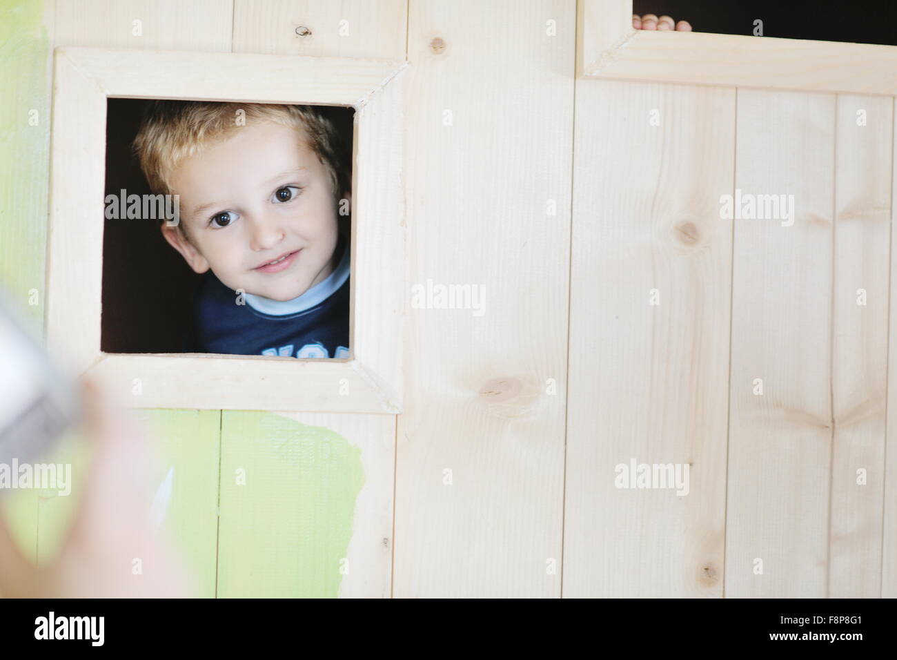happy cute child in a wooden window at playground Stock Photo - Alamy