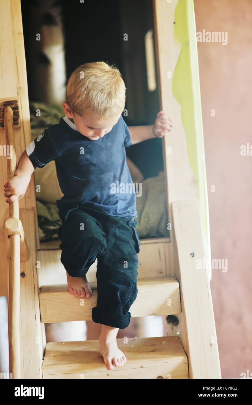 beautiful young child making first steps and have fun in play ground ...