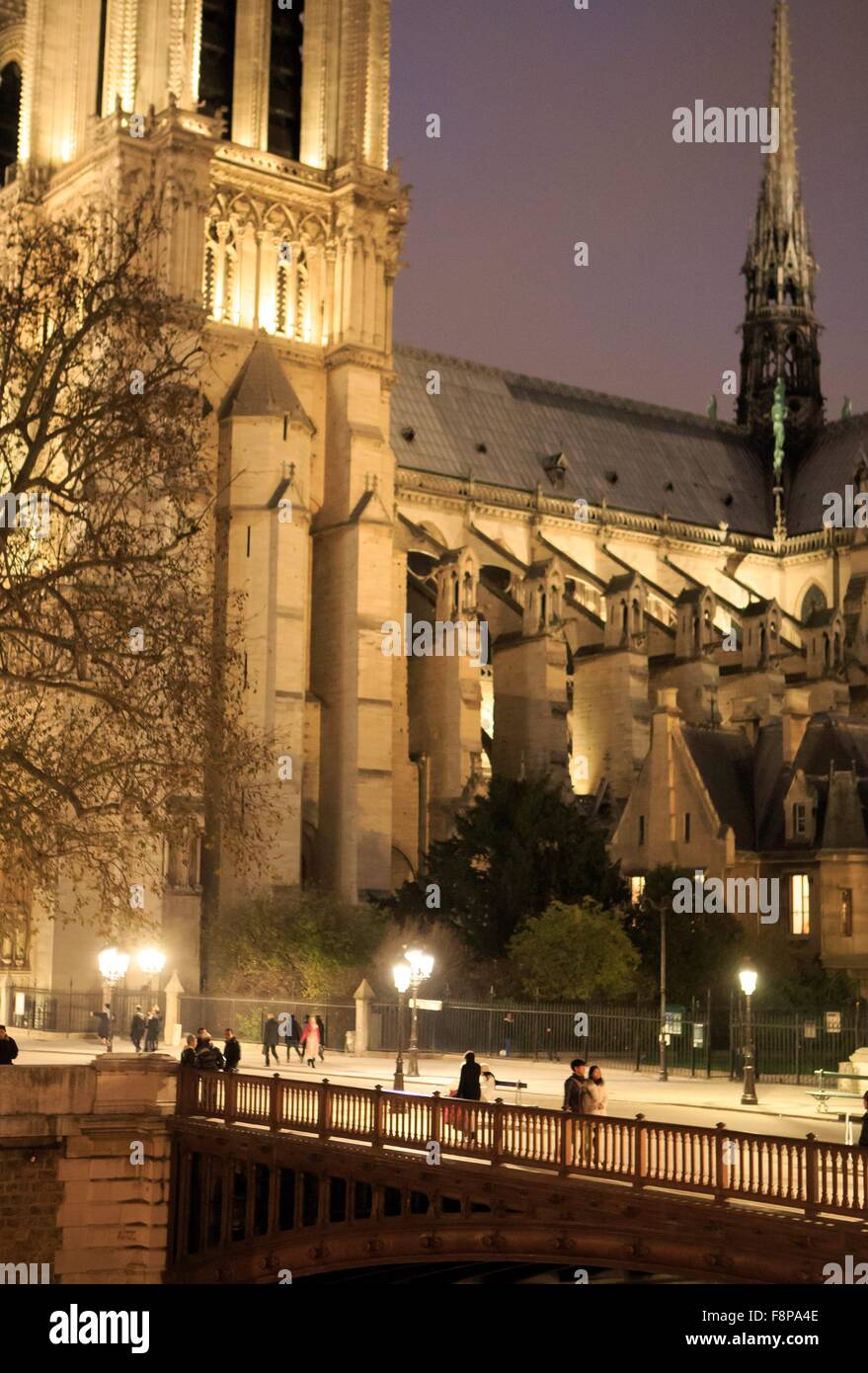Tourists cross a bridge over a canal towards the Notre Dame Cathedral ...
