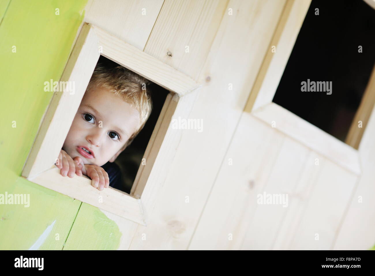happy cute child in a wooden window at playground Stock Photo - Alamy