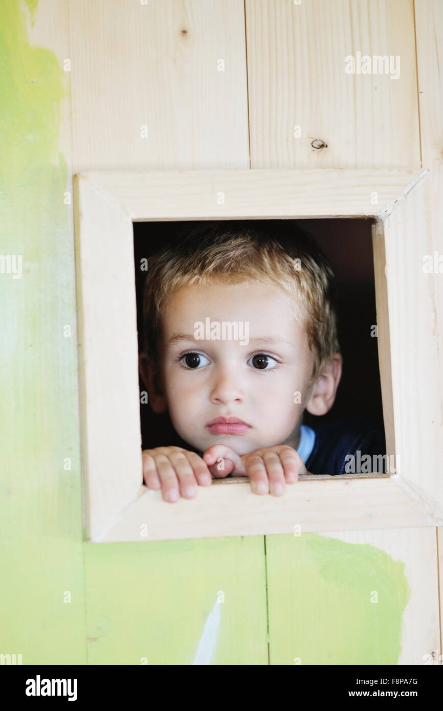 happy cute child in a wooden window at playground Stock Photo - Alamy