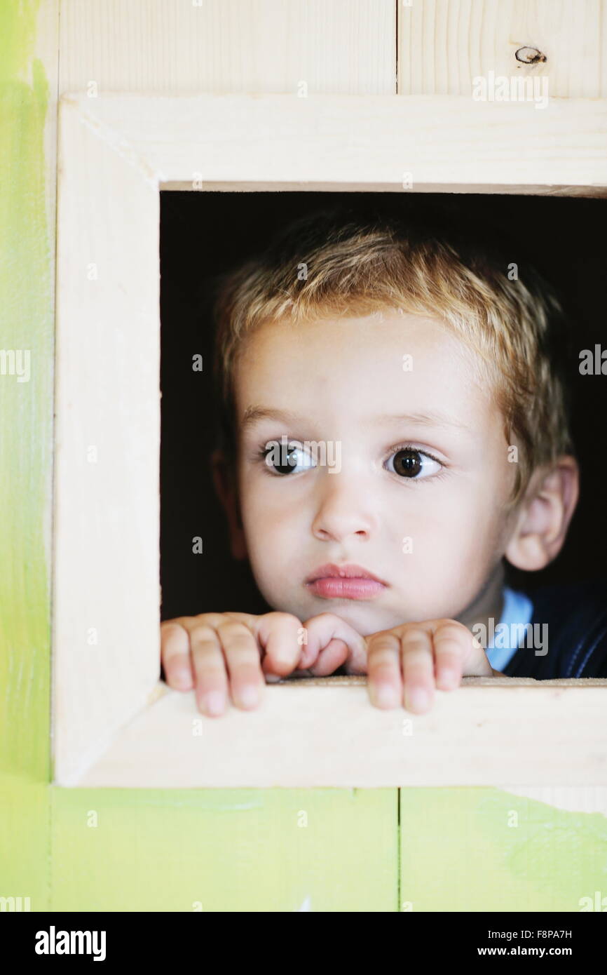 happy cute child in a wooden window at playground Stock Photo - Alamy