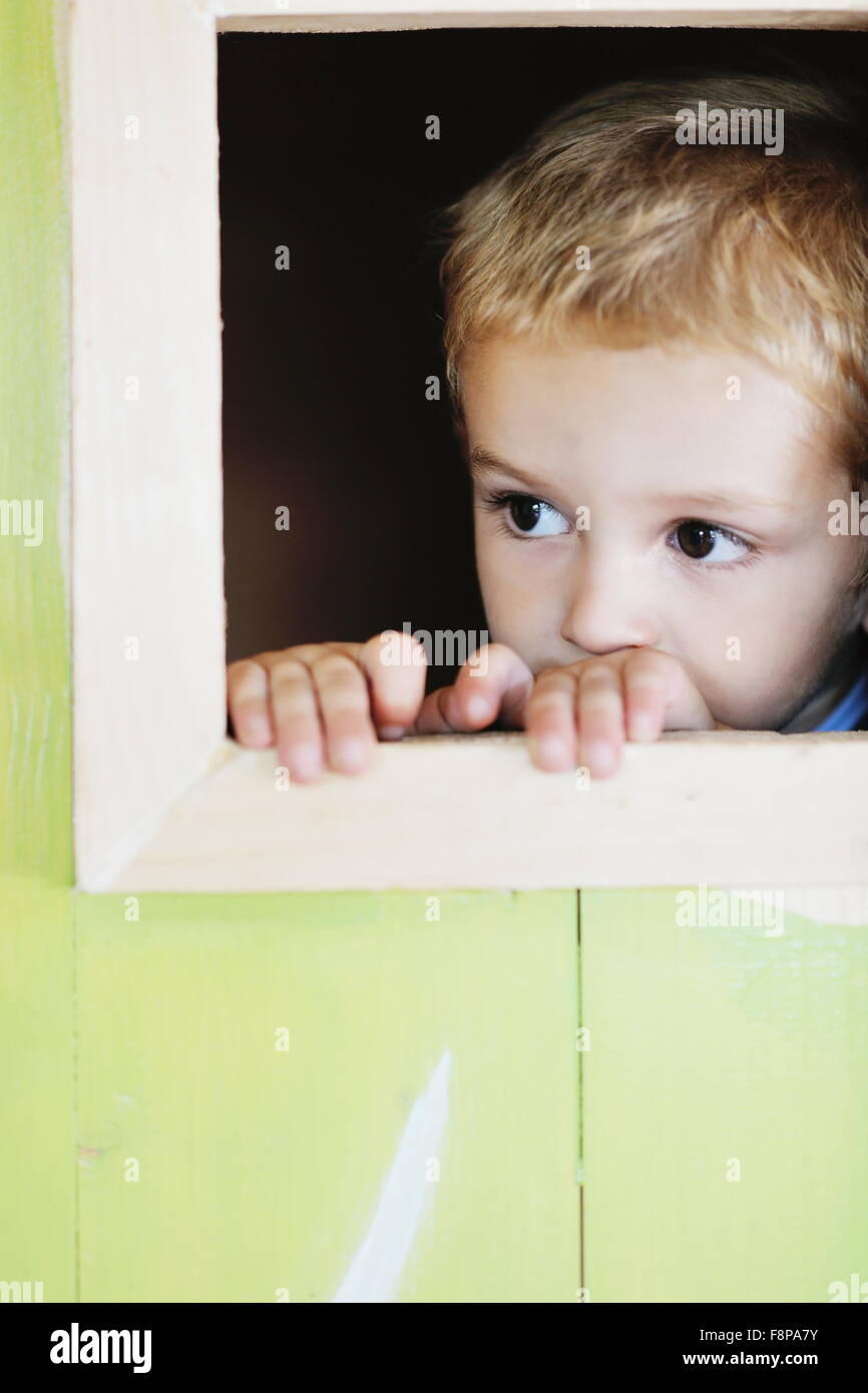 happy cute child in a wooden window at playground Stock Photo - Alamy