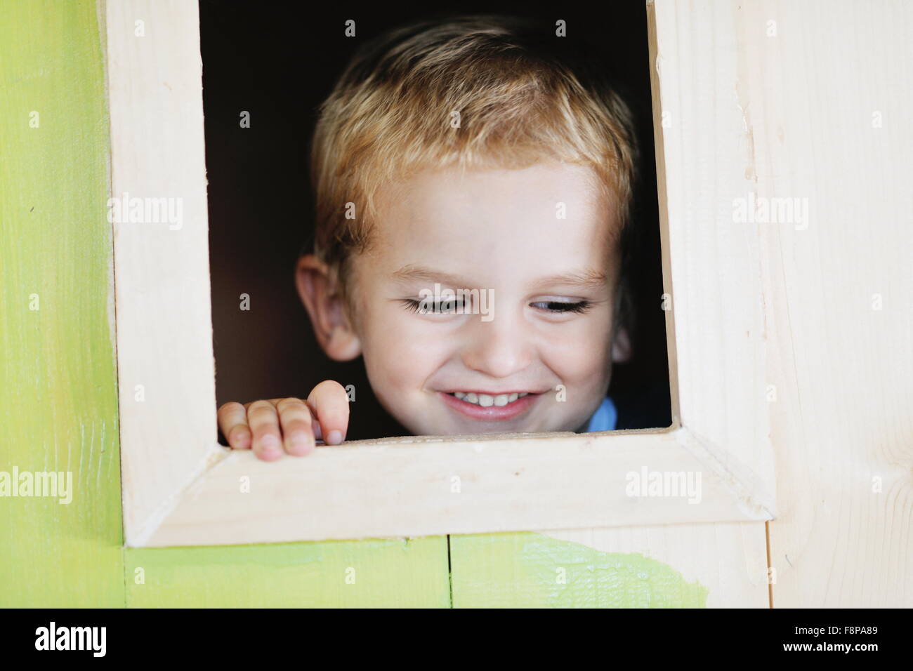 happy cute child in a wooden window at playground Stock Photo - Alamy