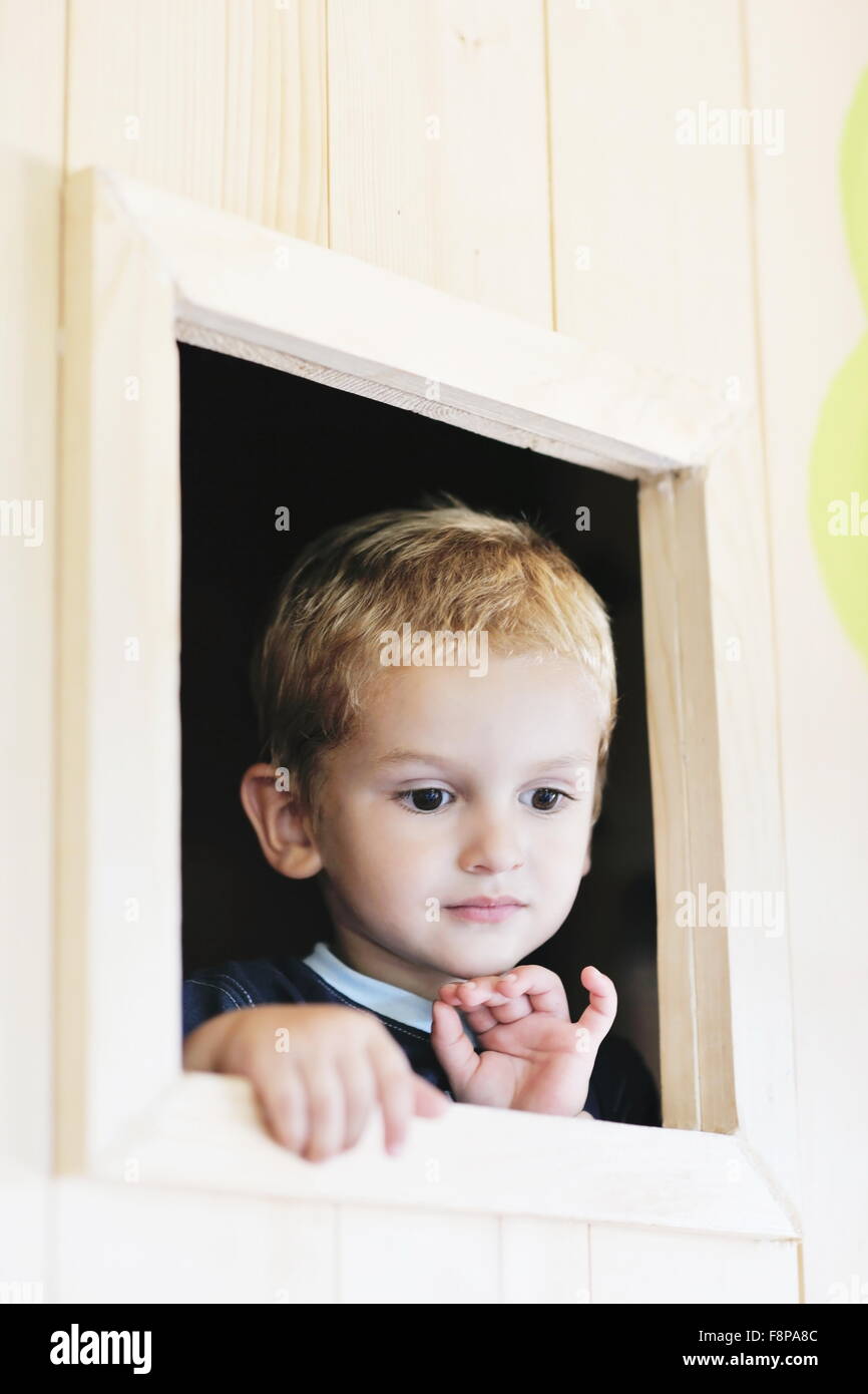 happy cute child in a wooden window at playground Stock Photo - Alamy