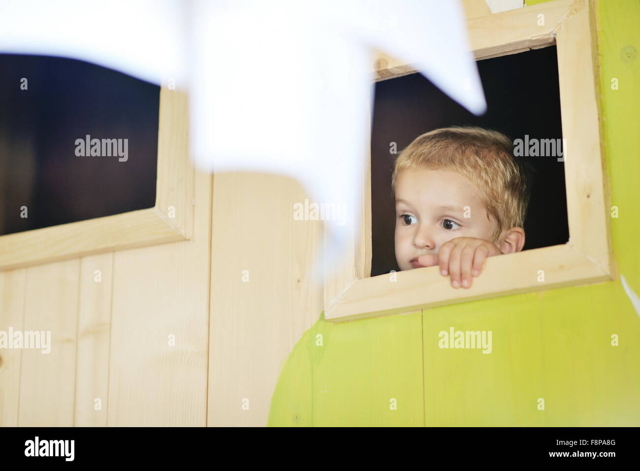 happy cute child in a wooden window at playground Stock Photo - Alamy