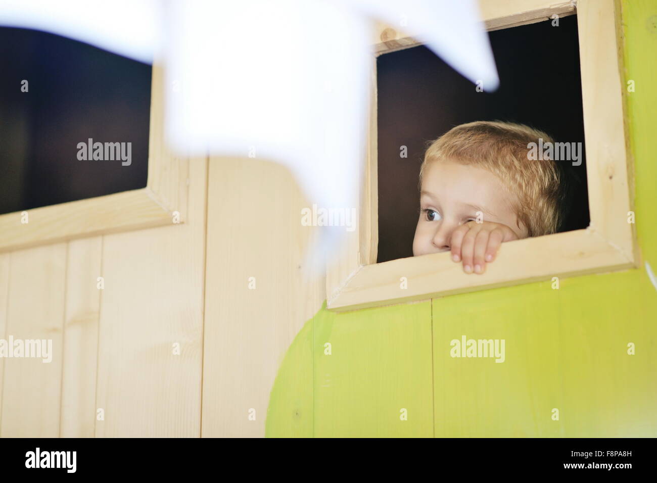 happy cute child in a wooden window at playground Stock Photo - Alamy