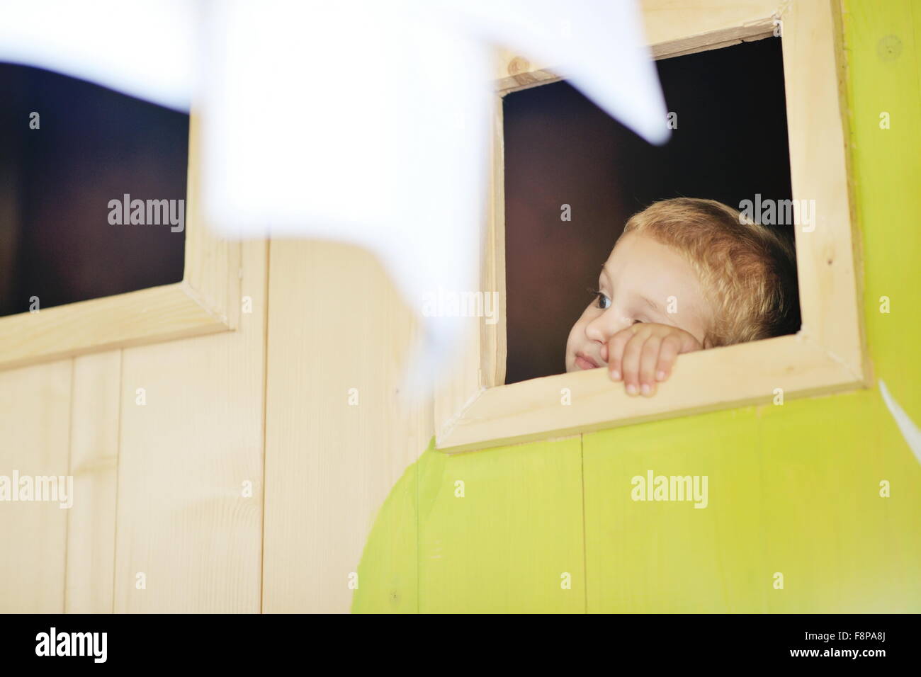 happy cute child in a wooden window at playground Stock Photo - Alamy