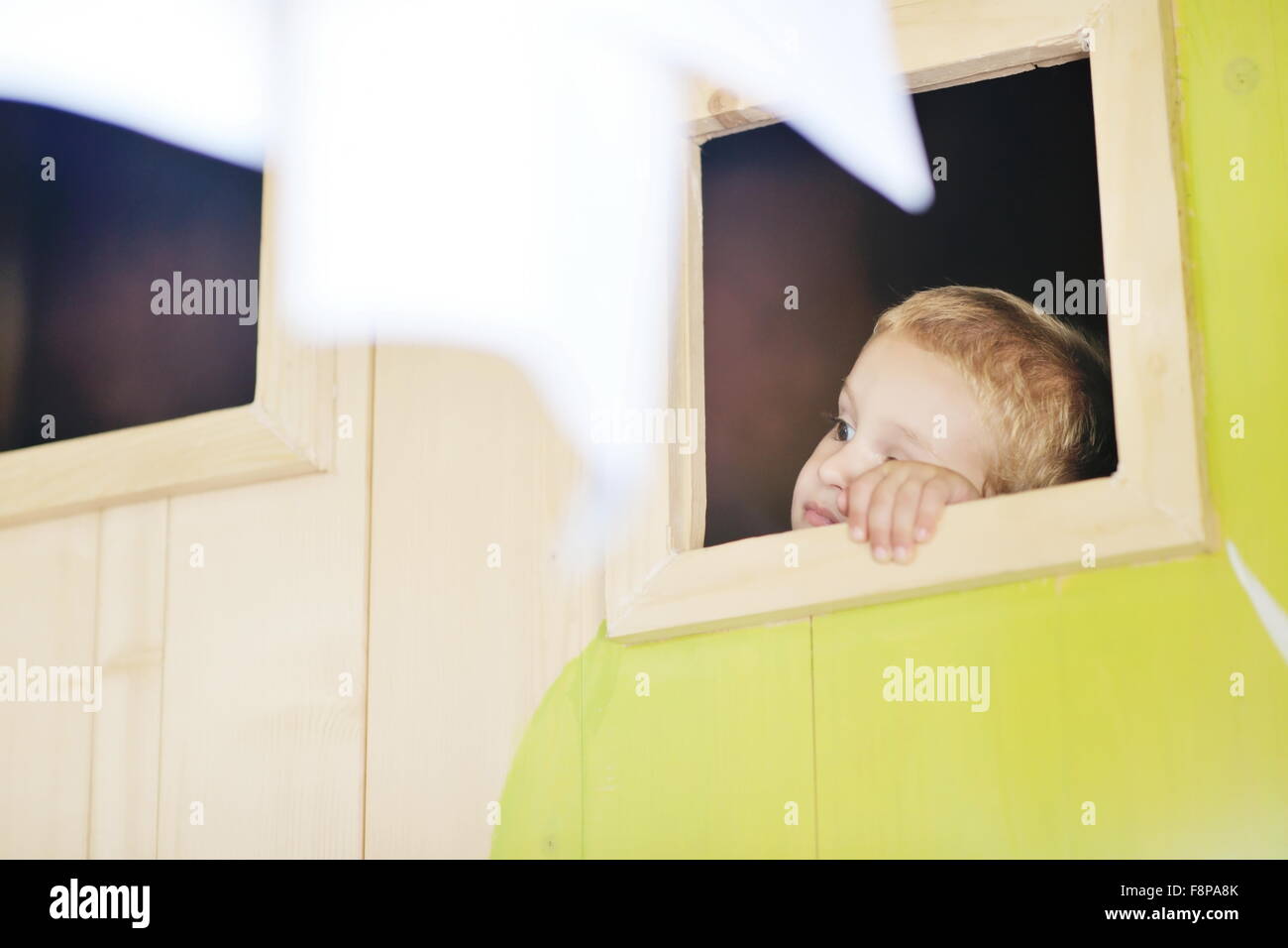happy cute child in a wooden window at playground Stock Photo - Alamy