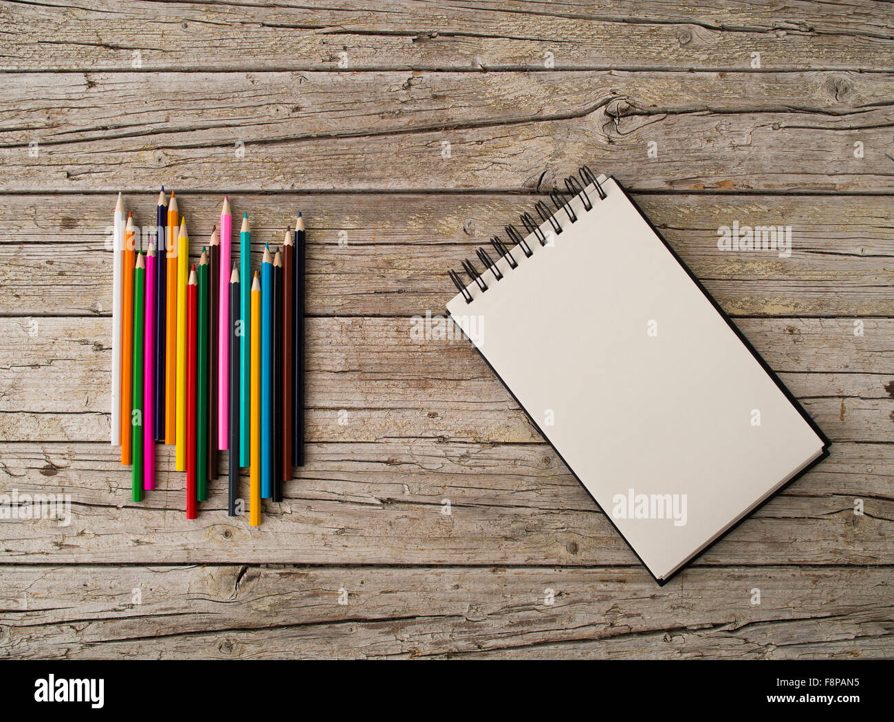 Colorful pencil crayons and notebook on wooden background Stock Photo ...