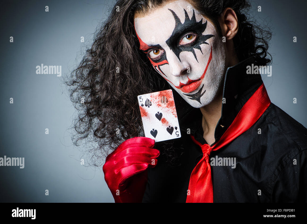 Evil clown with cards in dark room Stock Photo - Alamy