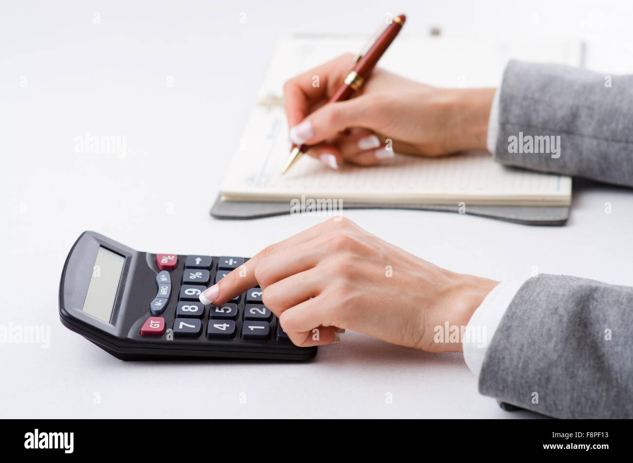 Hands working on the calculator Stock Photo - Alamy