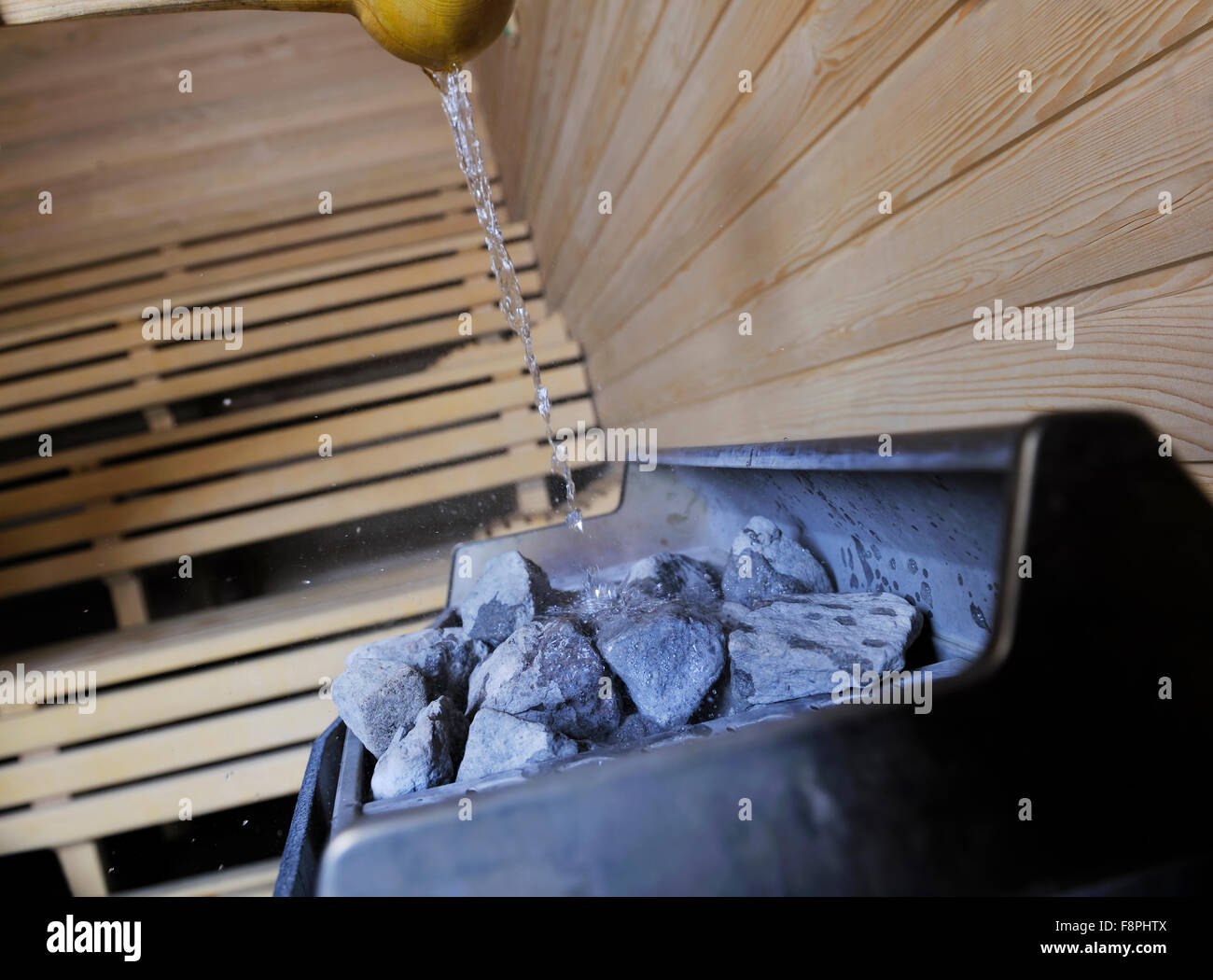 wooden luxury sauna indoor with hot stones and falling splashing water ...