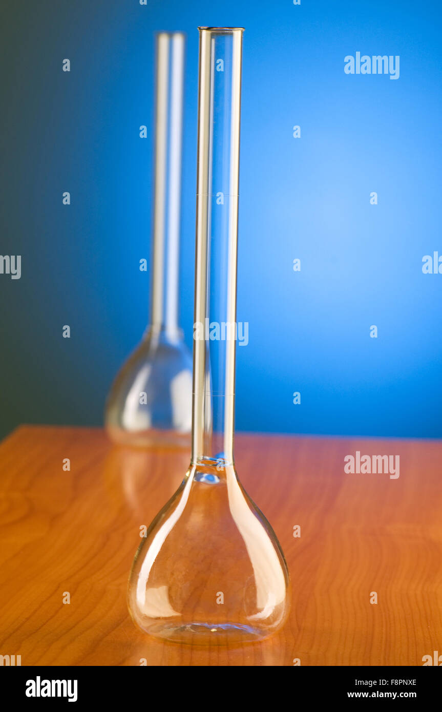 Glass retorts against blue gradient background Stock Photo - Alamy