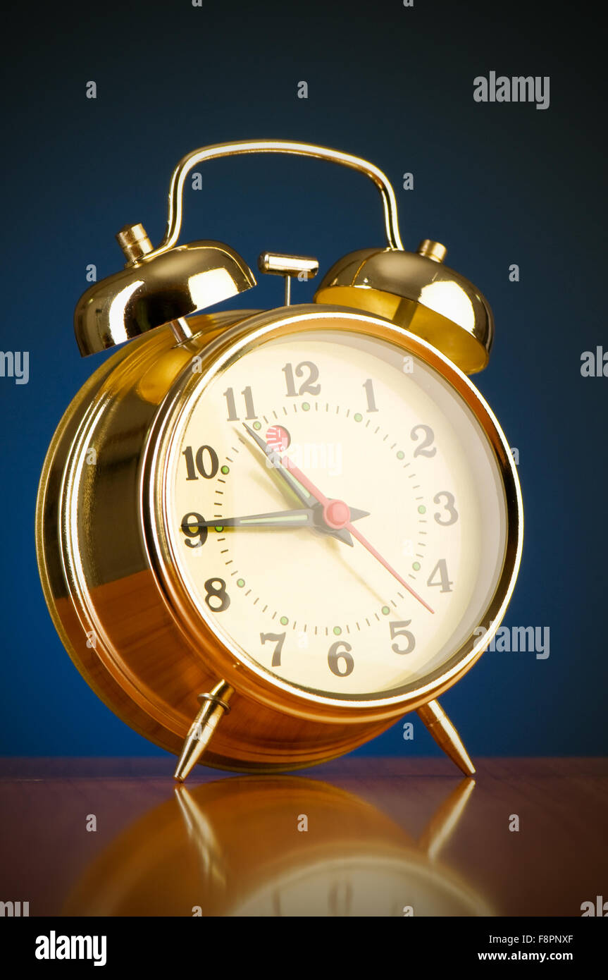 Alarm clock against colourful background Stock Photo - Alamy