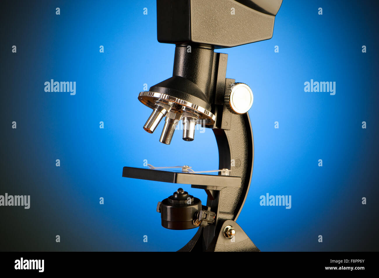 Microscope against blue gradient background Stock Photo - Alamy