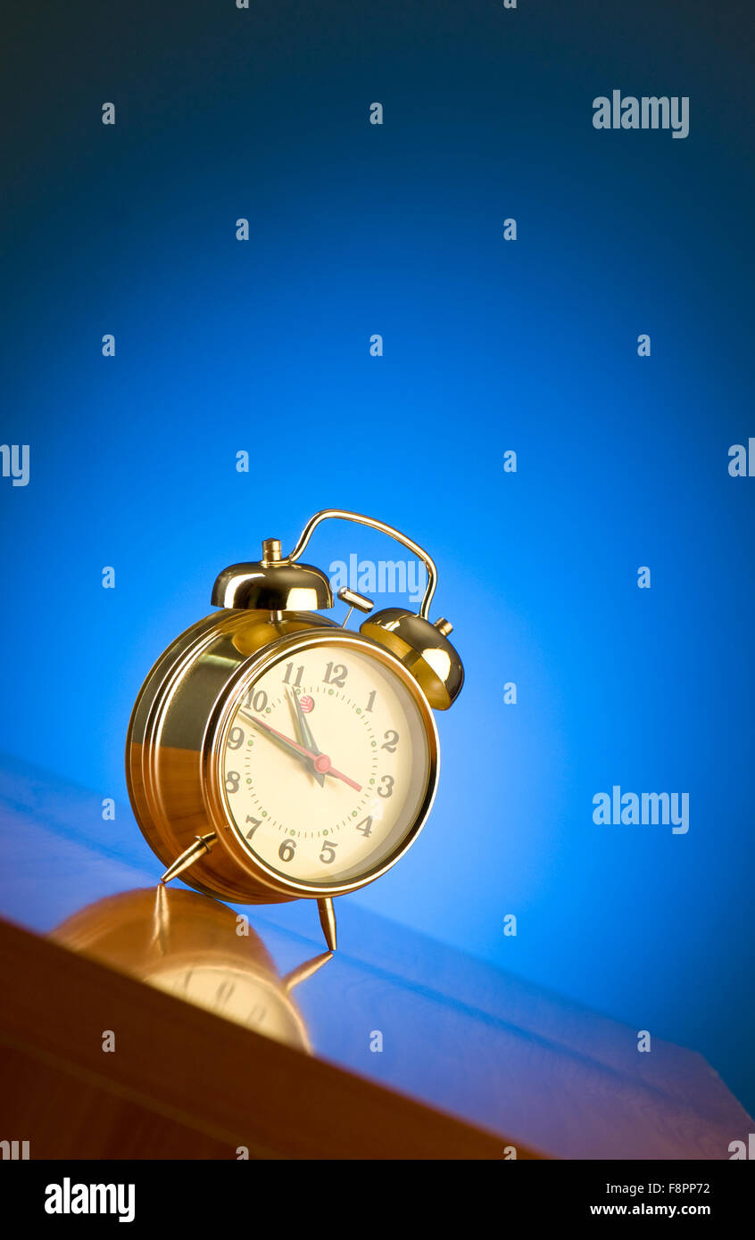 Alarm clock against colourful background Stock Photo - Alamy