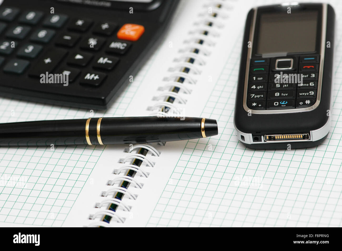 Calculator, ballpen and mobile phone on the notebook Stock Photo - Alamy