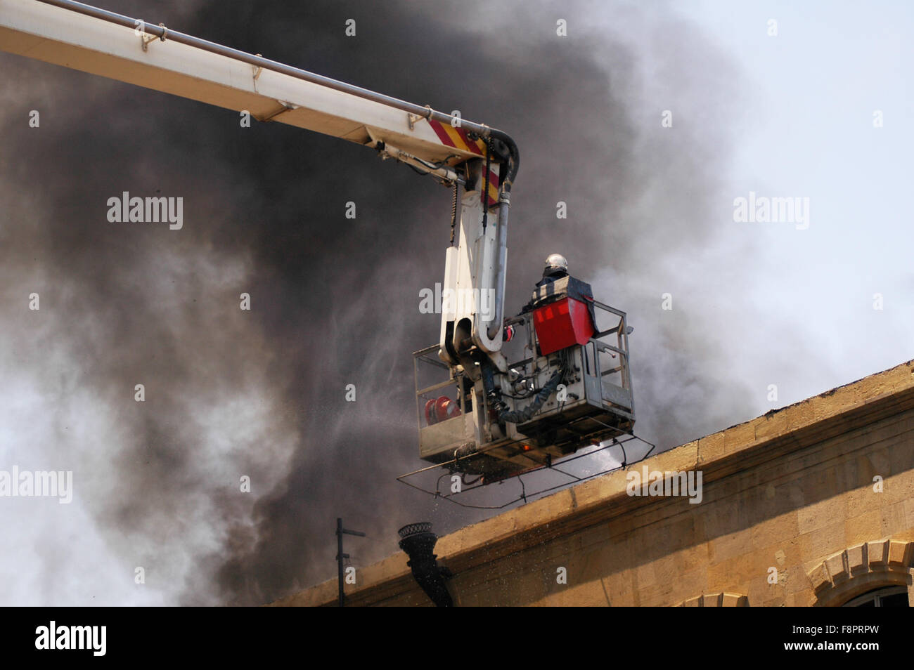 Firefighter on the firetruck boom during fire Stock Photo - Alamy