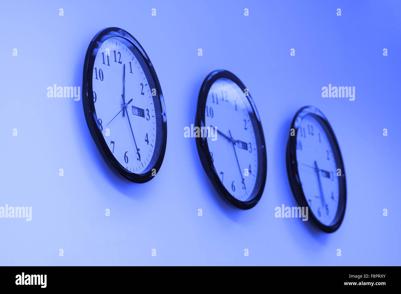 Row of round clocks on the wall Stock Photo - Alamy