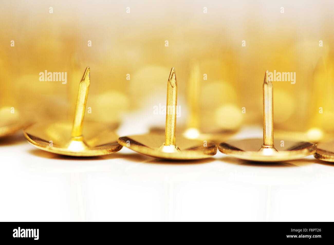 Golden pins isolated on the white background Stock Photo - Alamy