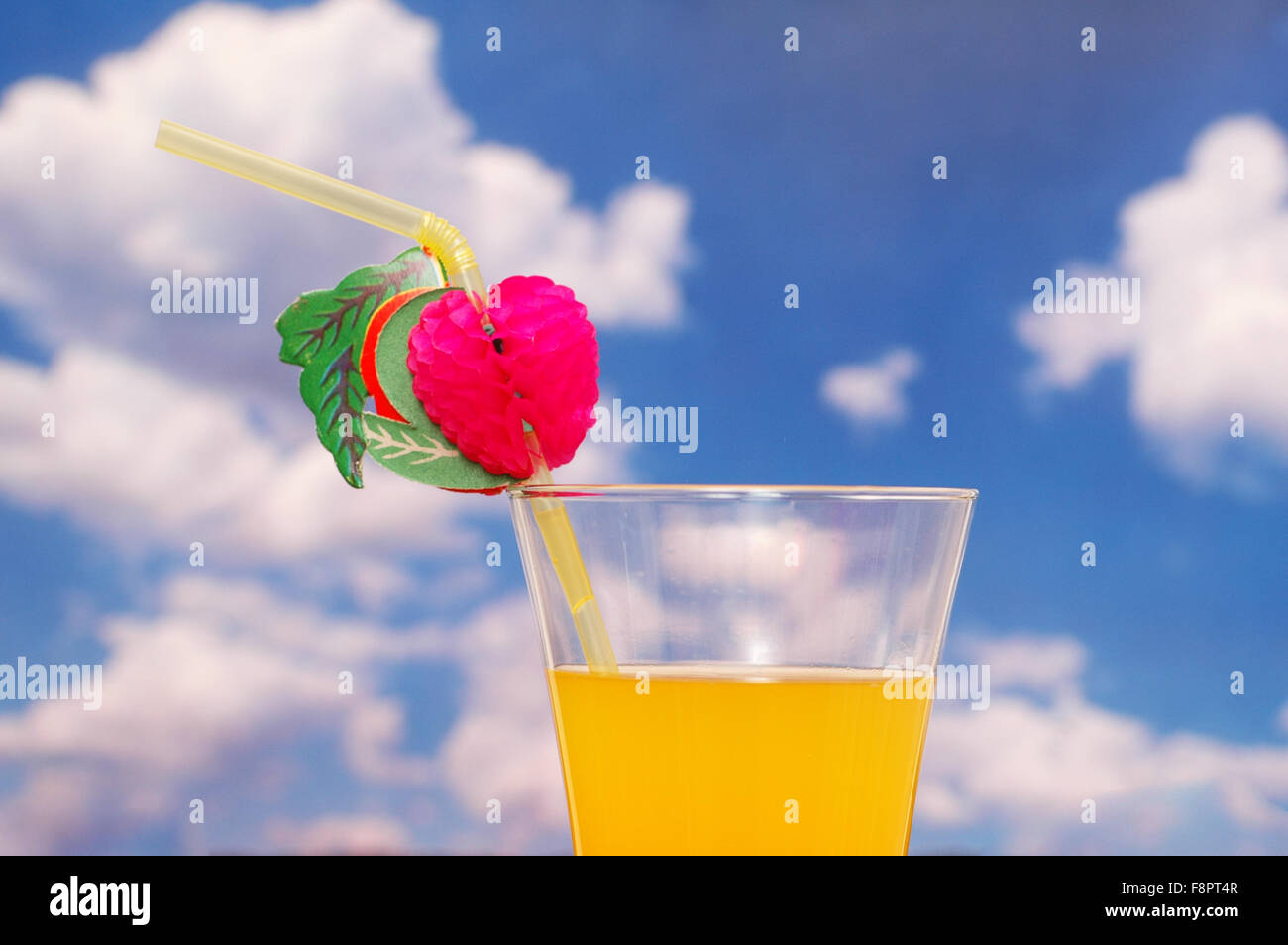 Orange juice with straw against cloudy sky Stock Photo - Alamy