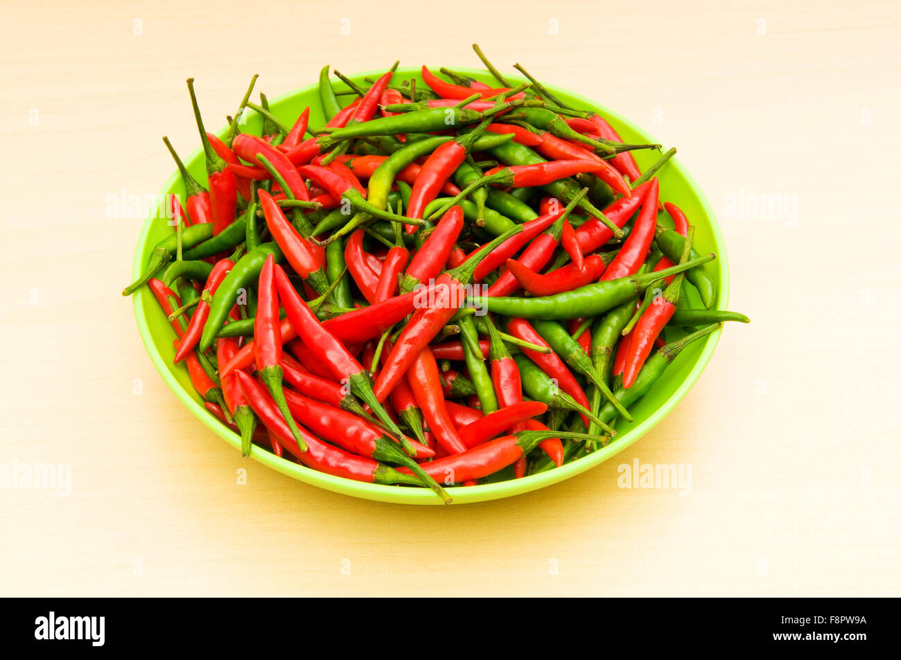 Hot peppers in the plate on wooden table Stock Photo - Alamy