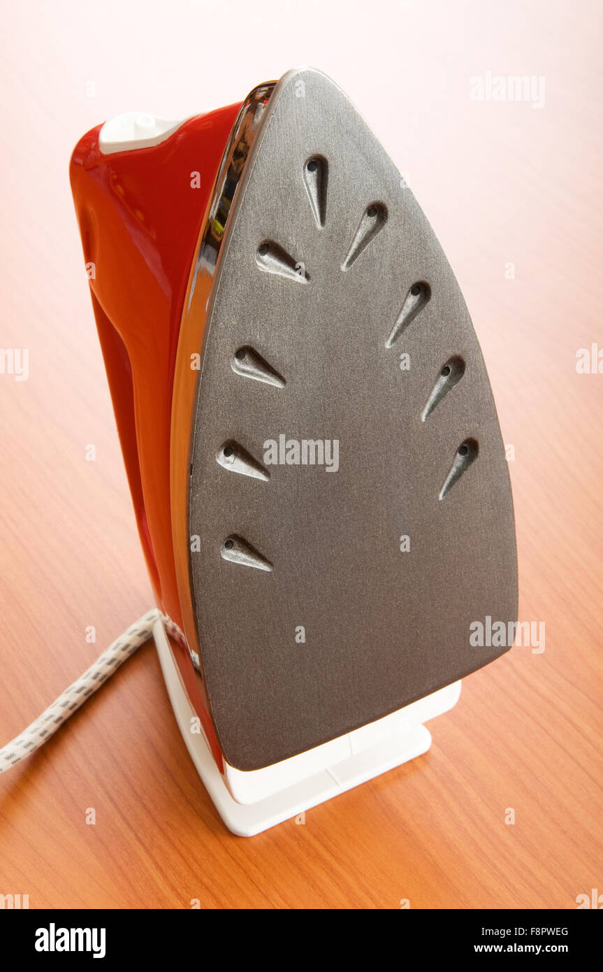 Modern electric iron on the wooden background Stock Photo - Alamy