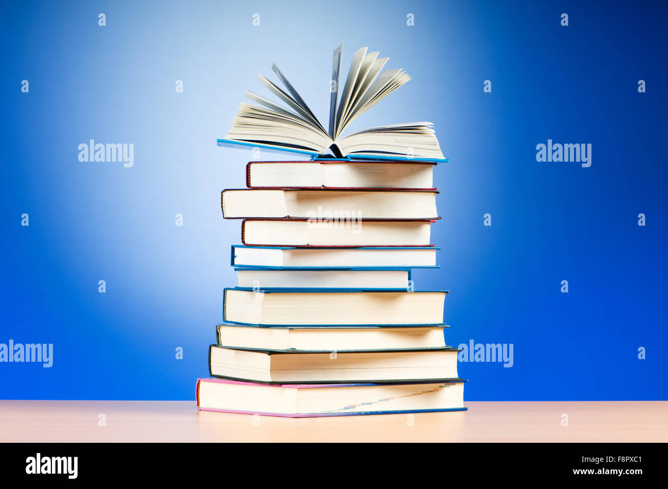 Stack of text books against gradient background Stock Photo - Alamy