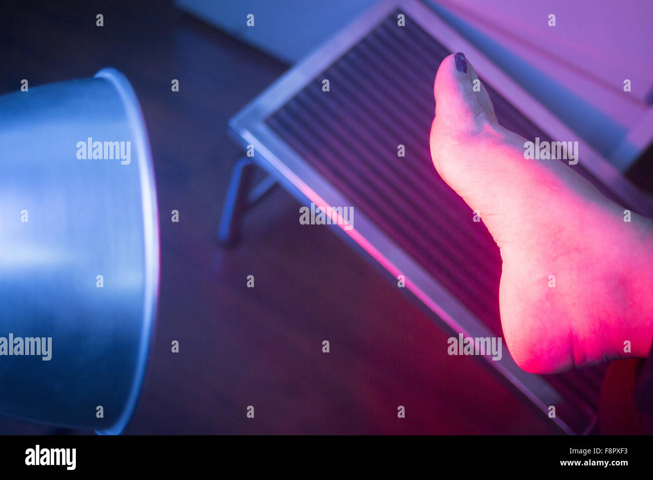 Patient foot in red physiotherapy heat treatment under hot light Stock ...