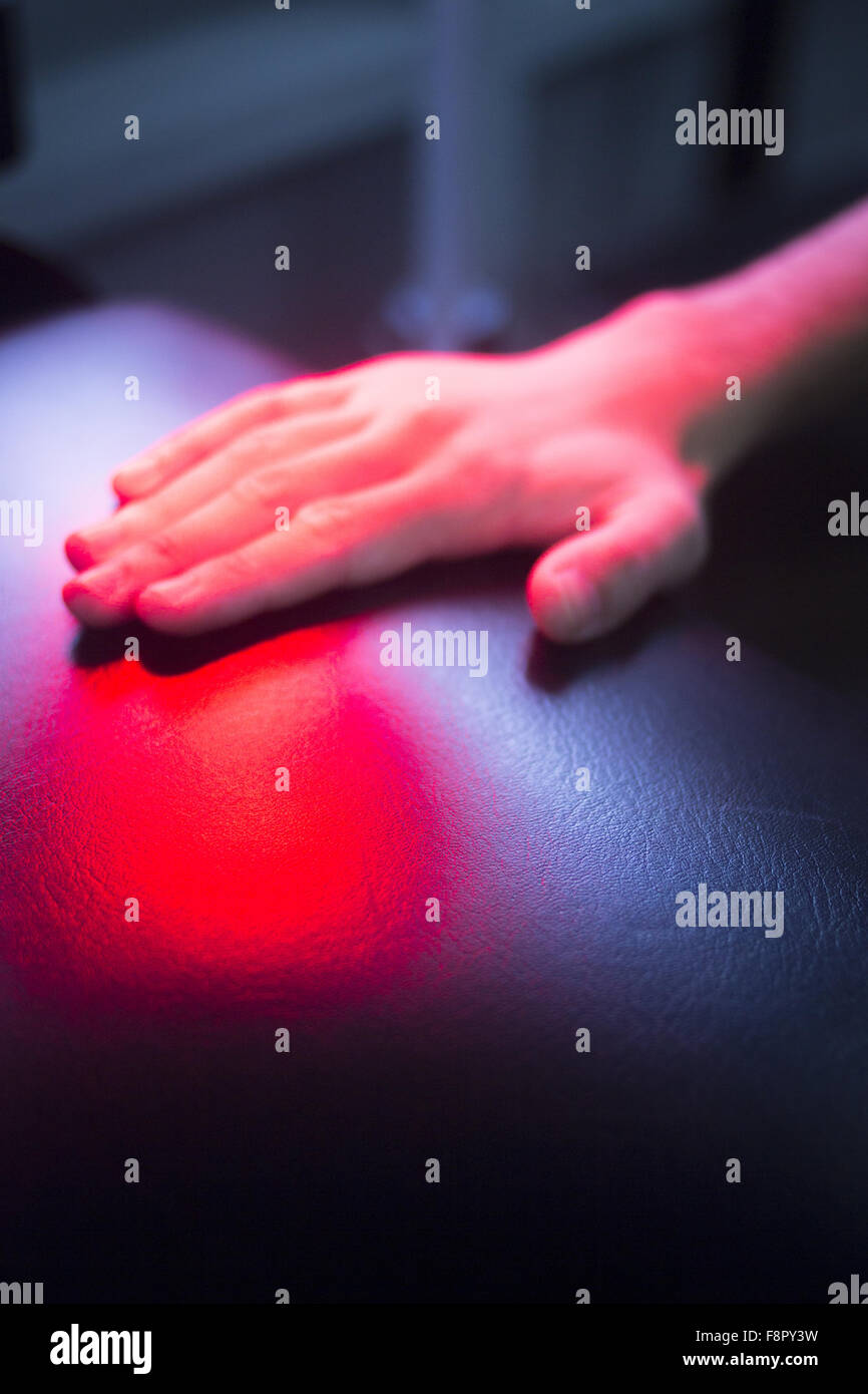 Patient hand in red physiotherapy heat treatment under hot light Stock ...