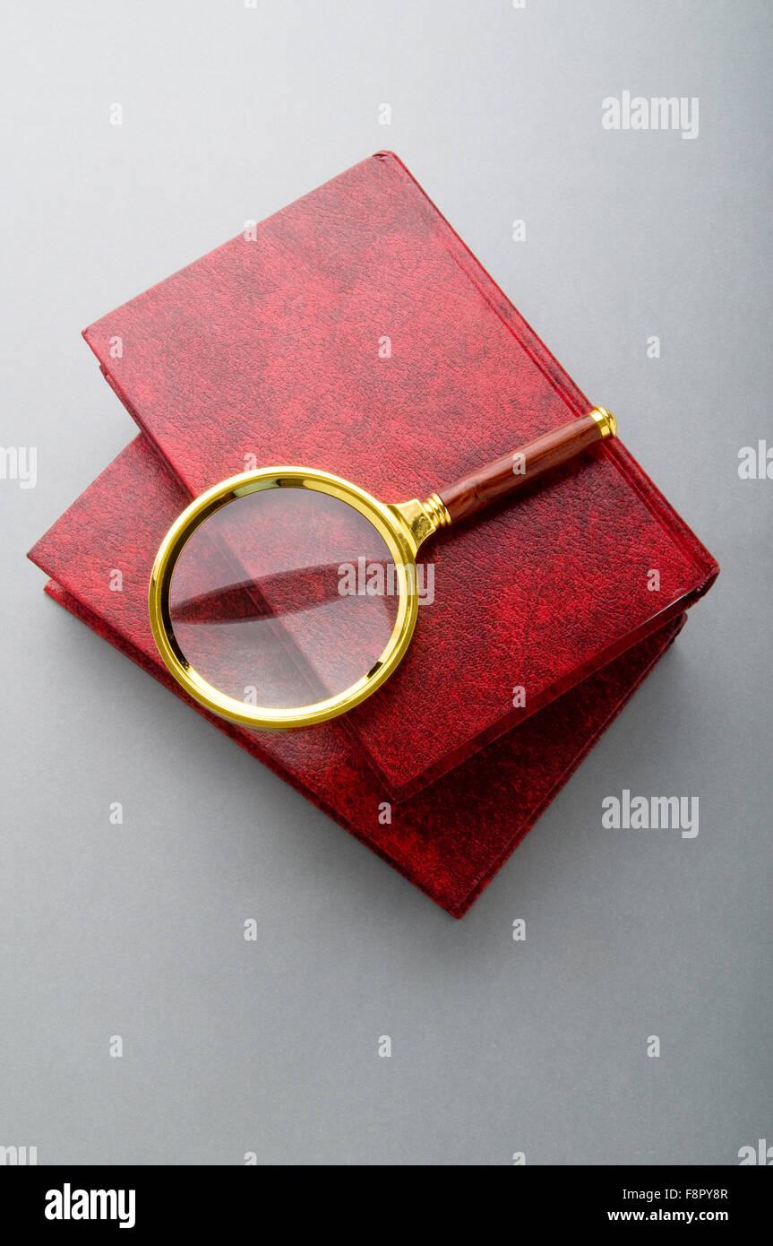 Magnifying glass over the stack of books Stock Photo - Alamy